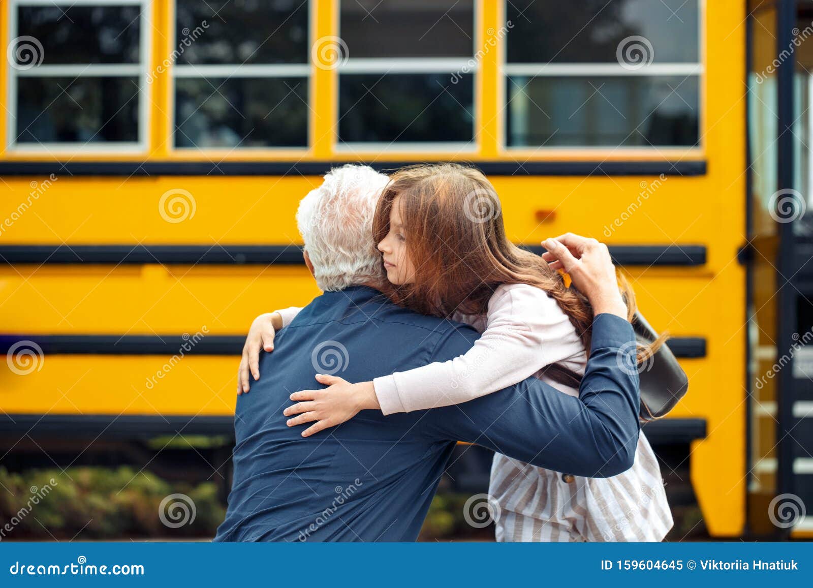 Father And Daughter Hugging Near School Bus Saying Bye Close Up Stock