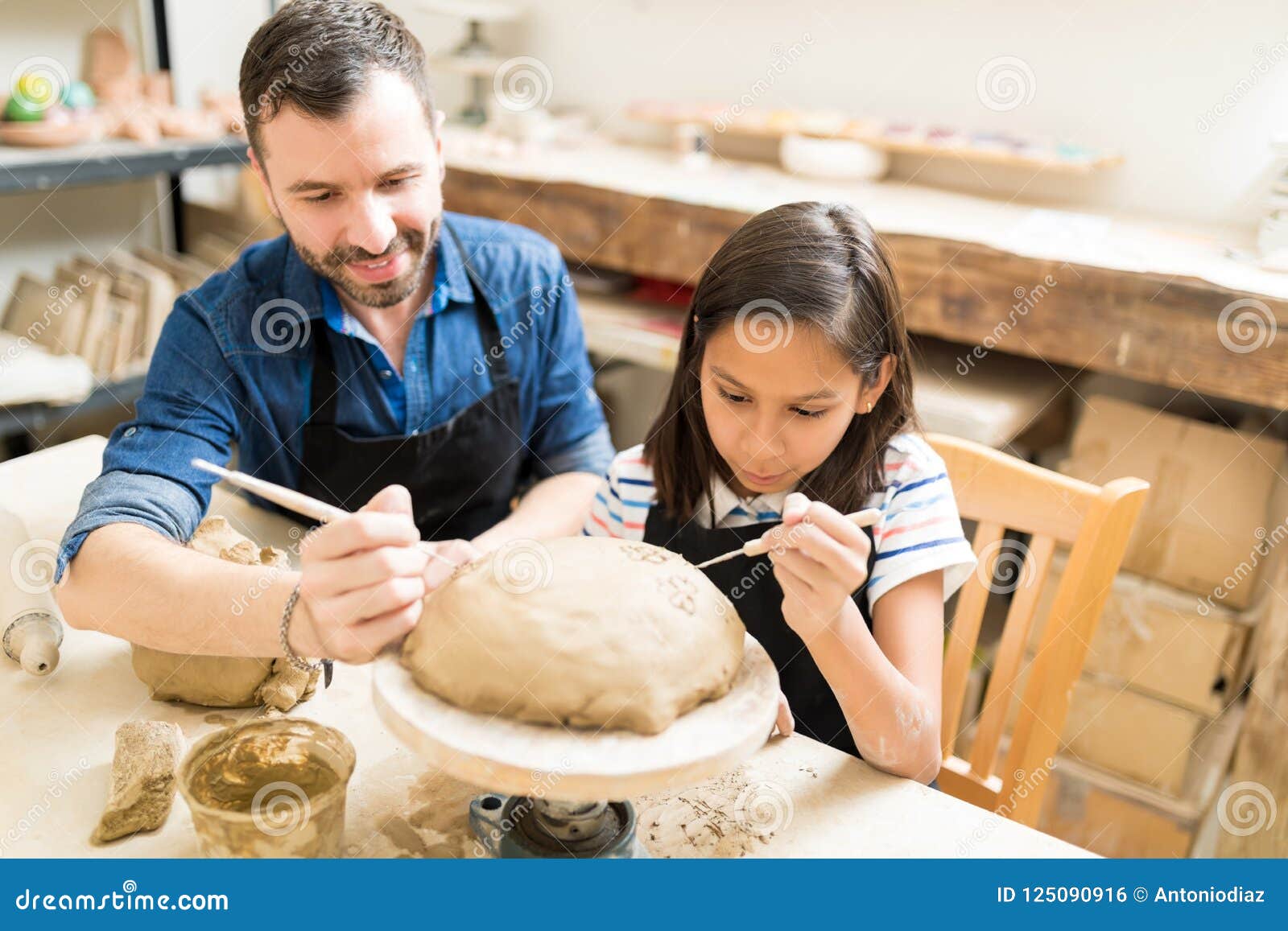 Father and Daughter Making Design on Clay Using Sculpting Tools Stock ...