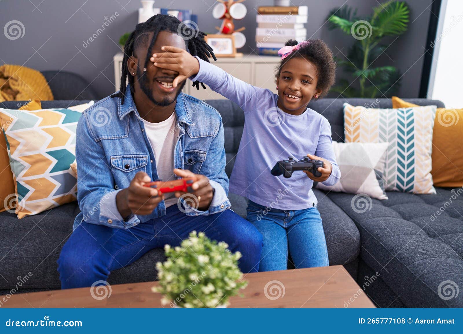 Father and Daughter Playing Video Game Sitting on Sofa at Home Stock ...