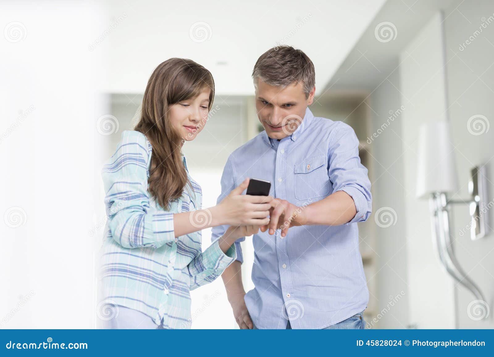 Father and Daughter Using Smart Phone at Home Stock Photo - Image of ...