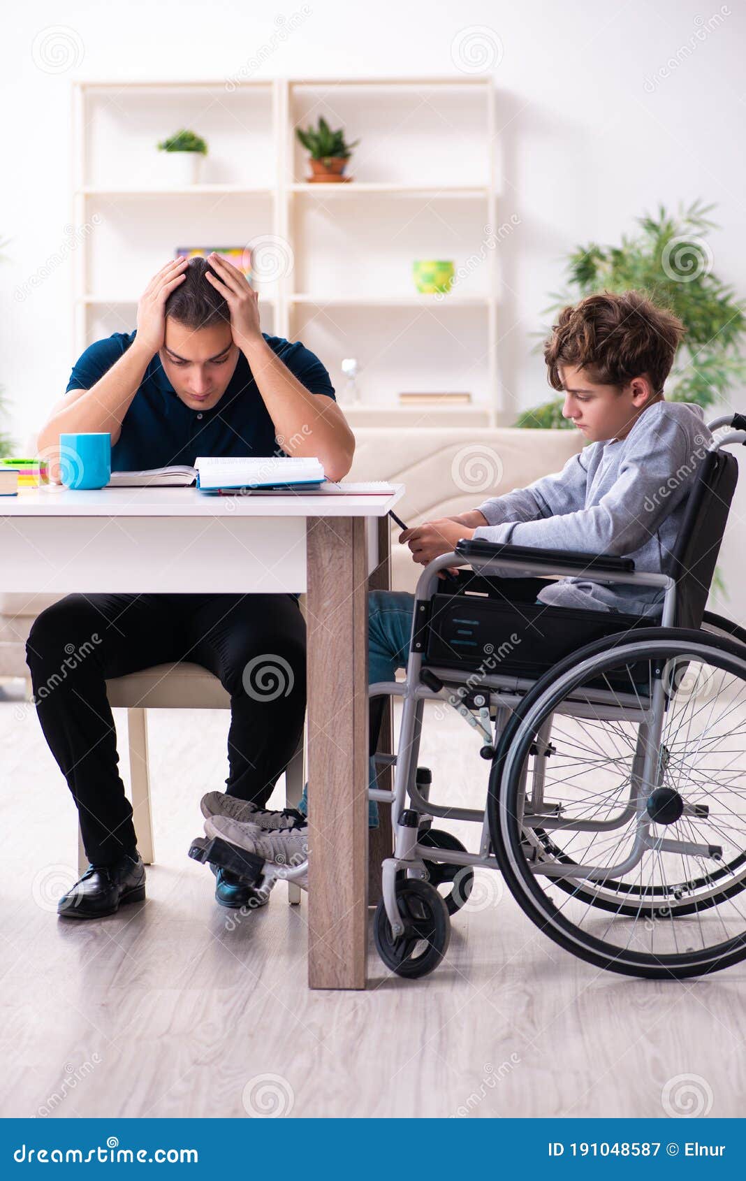 Father And Disabled Son In Wheelchair Visiting Grave At Cemetery Stock ...