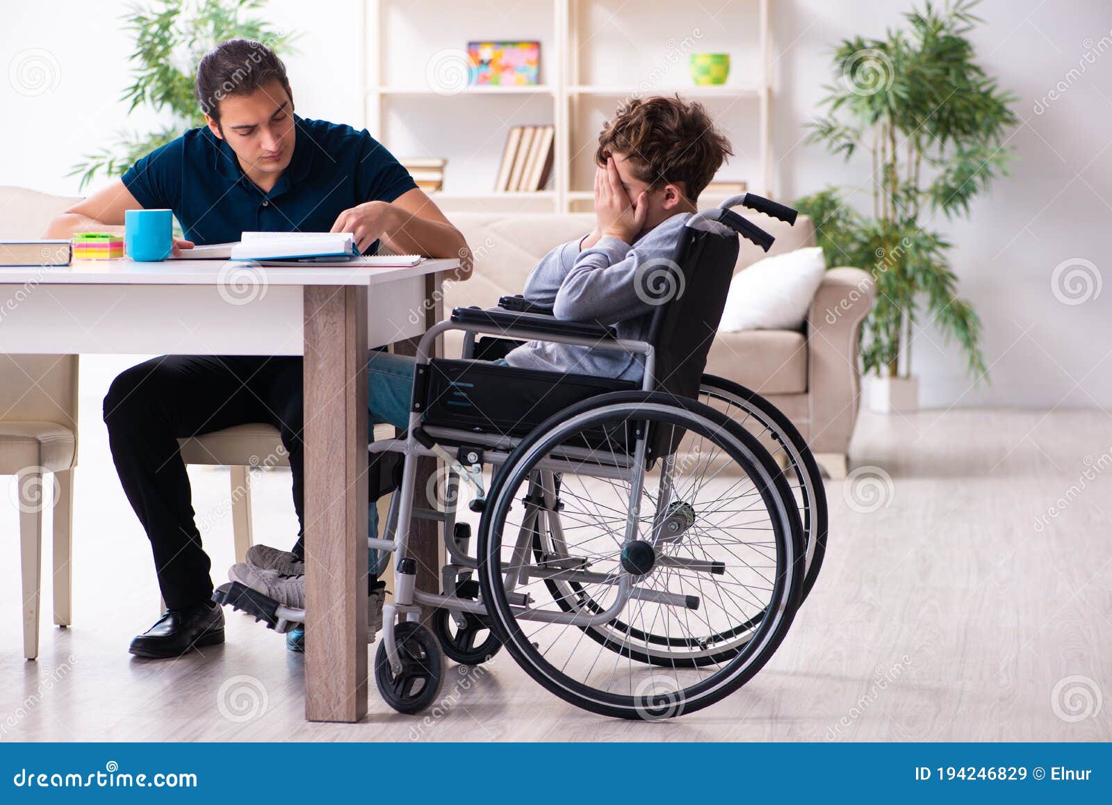 Father And Disabled Son In Wheelchair Visiting Grave At Cemetery Stock ...