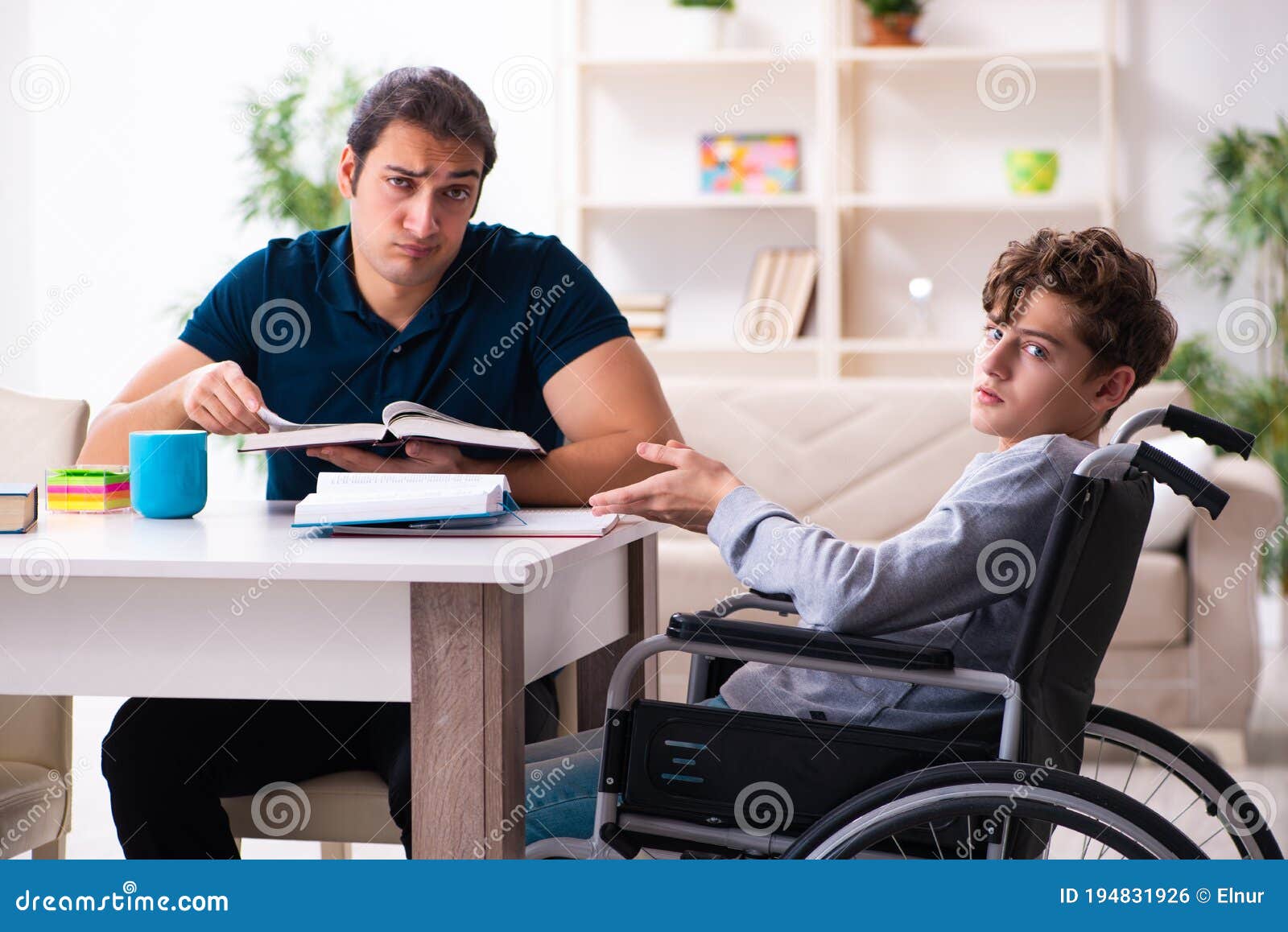 Father And Disabled Son In Wheelchair Visiting Grave At Cemetery Stock ...