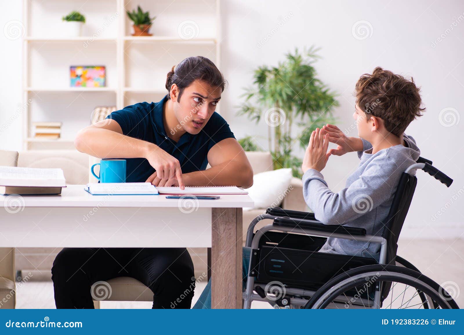 Father And Disabled Son In Wheelchair Visiting Grave At Cemetery Stock ...
