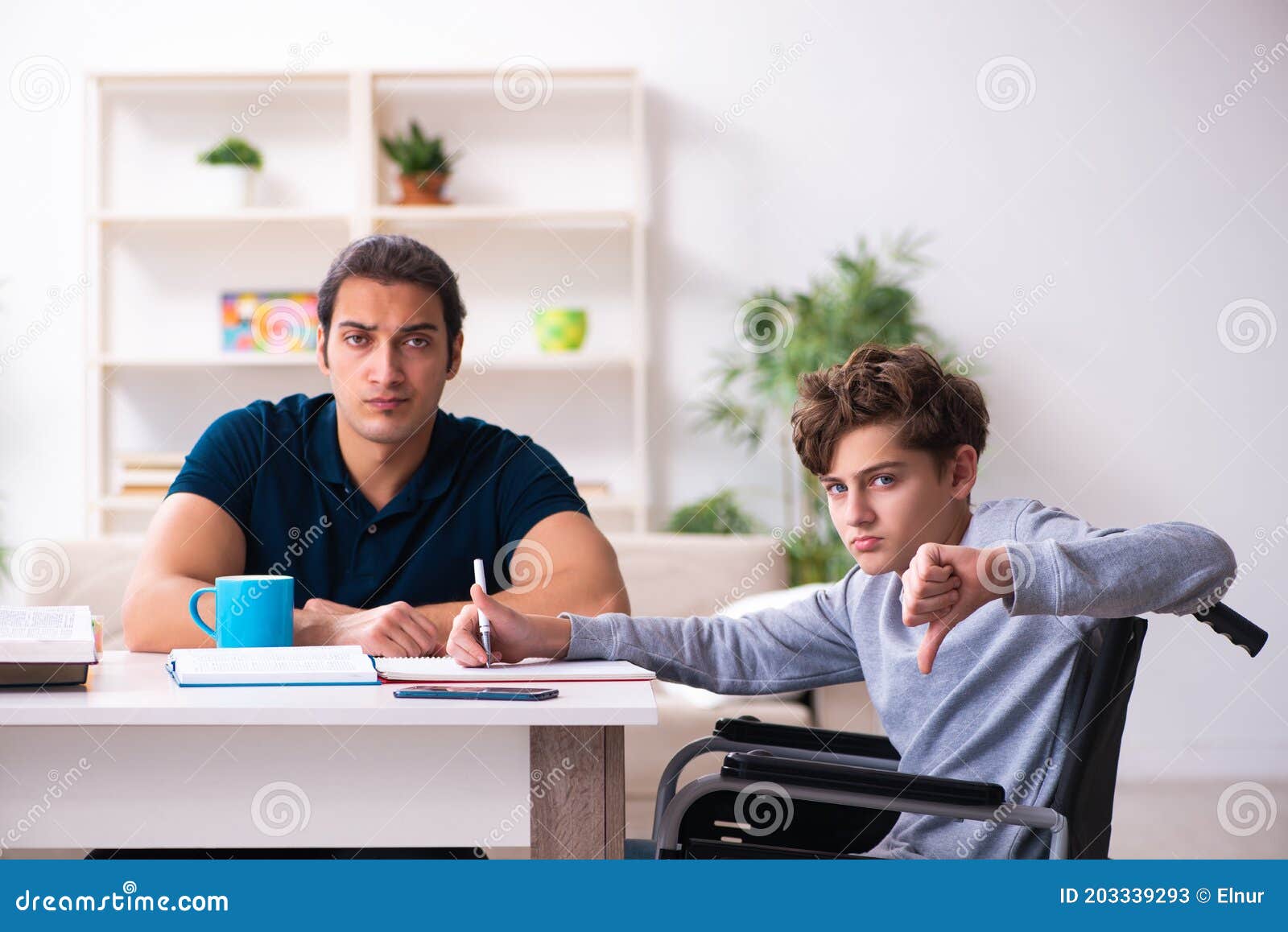 Father And Disabled Son In Wheelchair Visiting Grave At Cemetery Stock ...