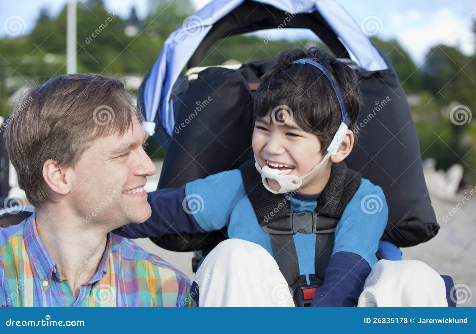 Father With Disabled Son In Wheelchair On Cold Foggy Beach Royalty-Free ...