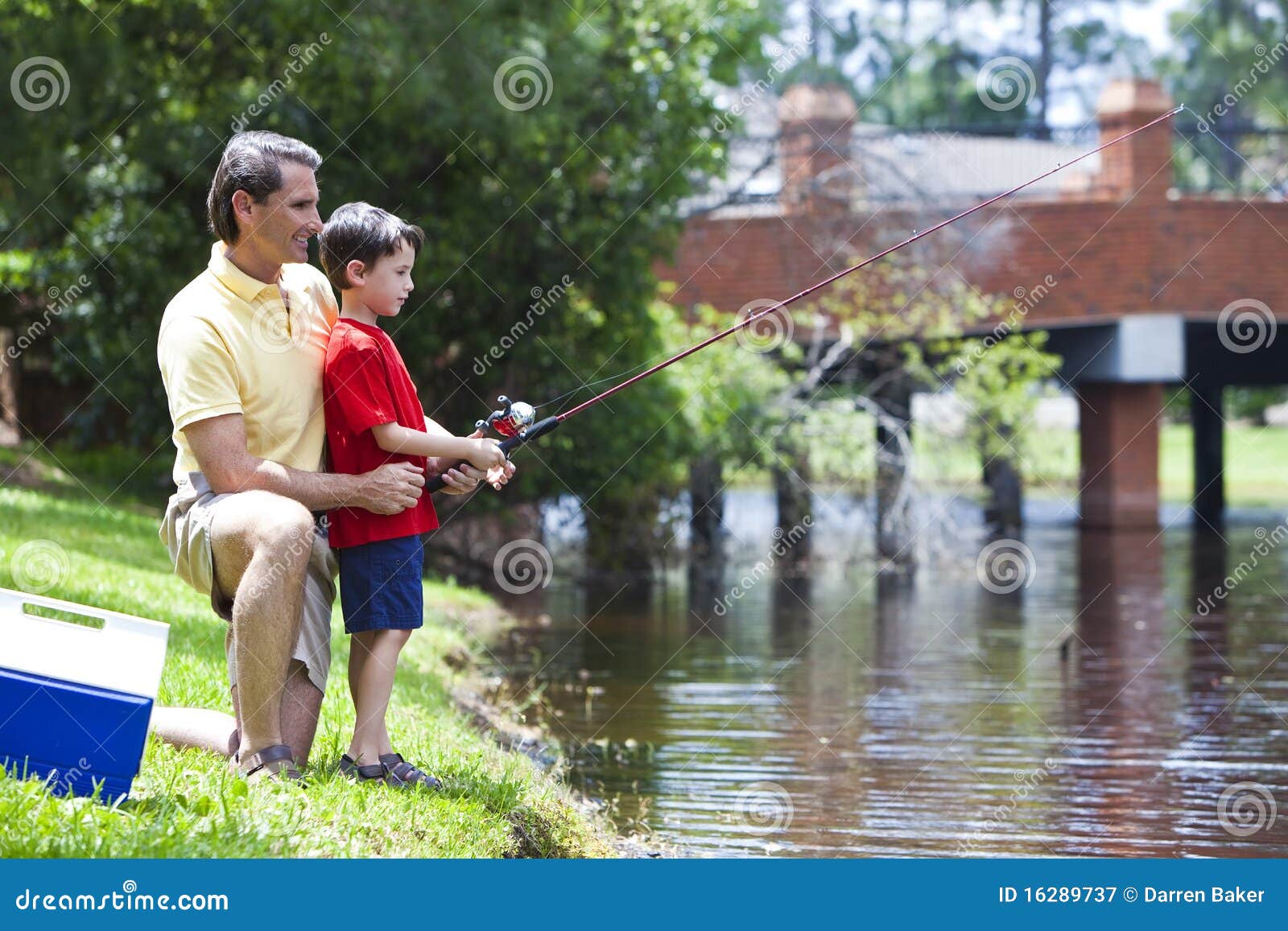 Father With Son On The River Enjoying Fishing Holding Fishing Rods ...