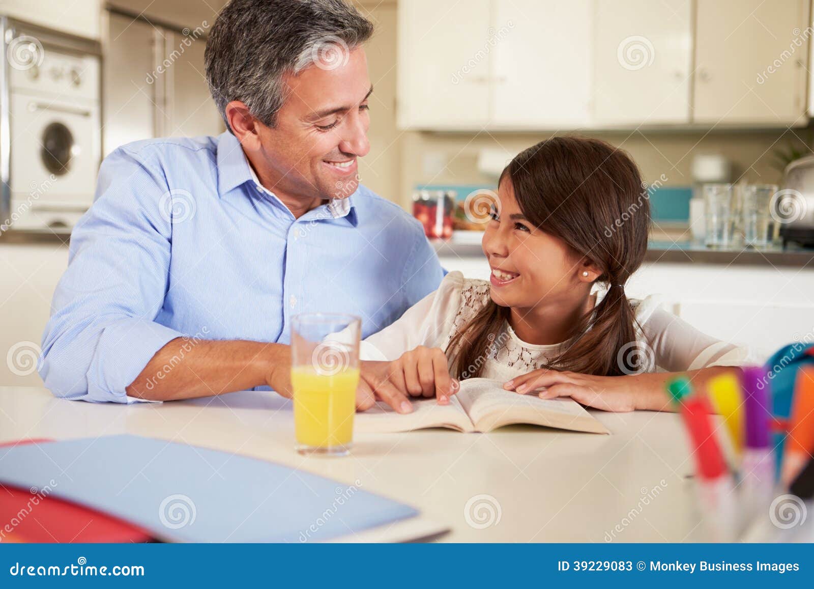 Father Helping Daughter with Reading Homework at Table Stock Image ...