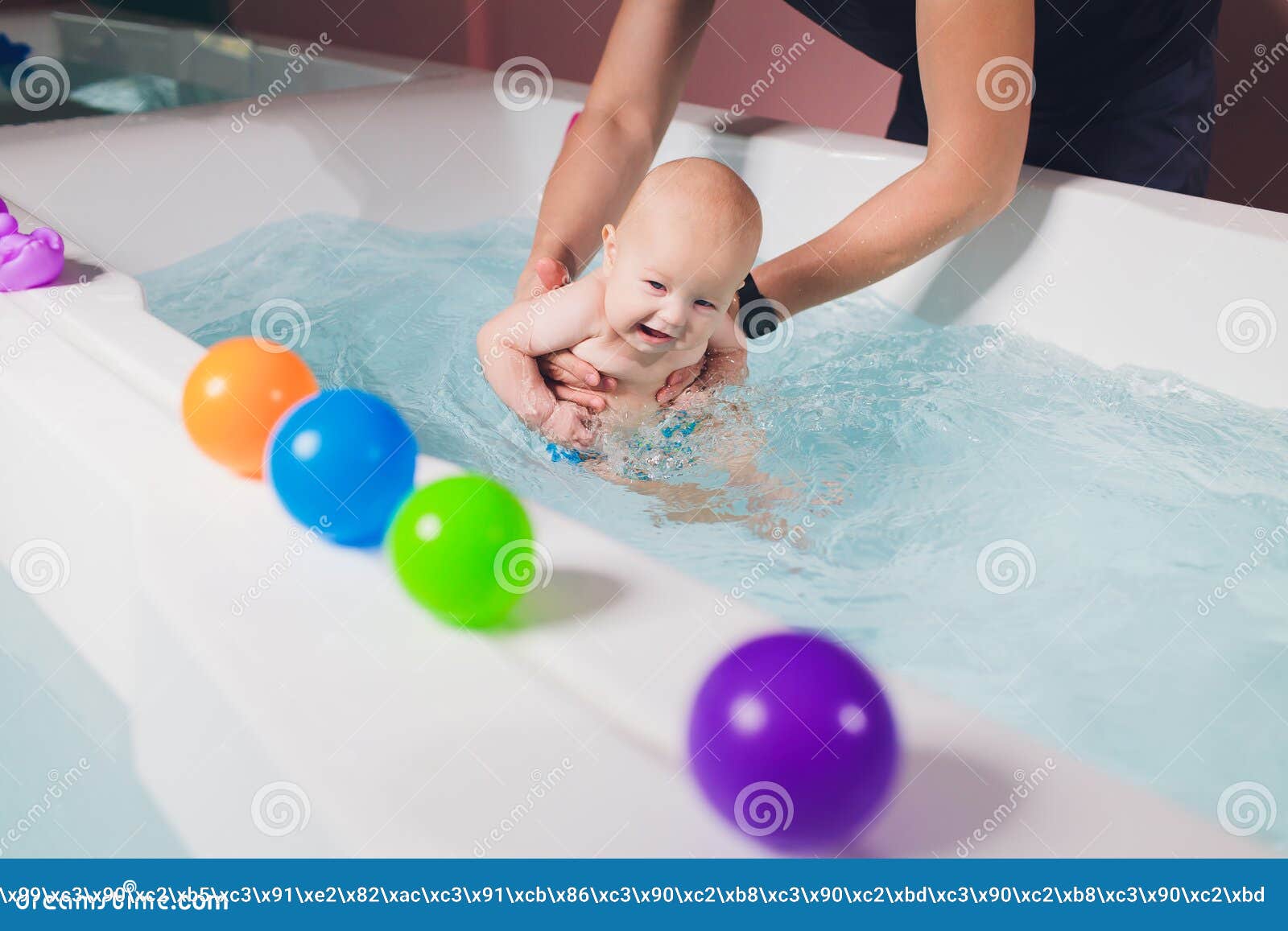 A Father Helps is Infant Boy during Swimming Lessons in the Pool. Stock ...