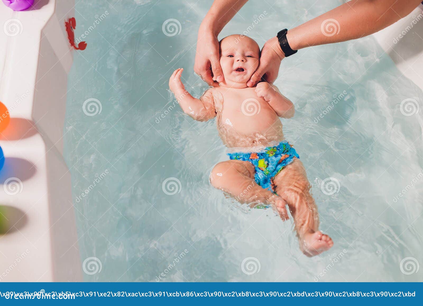 A Father Helps is Infant Boy during Swimming Lessons in the Pool. Stock ...