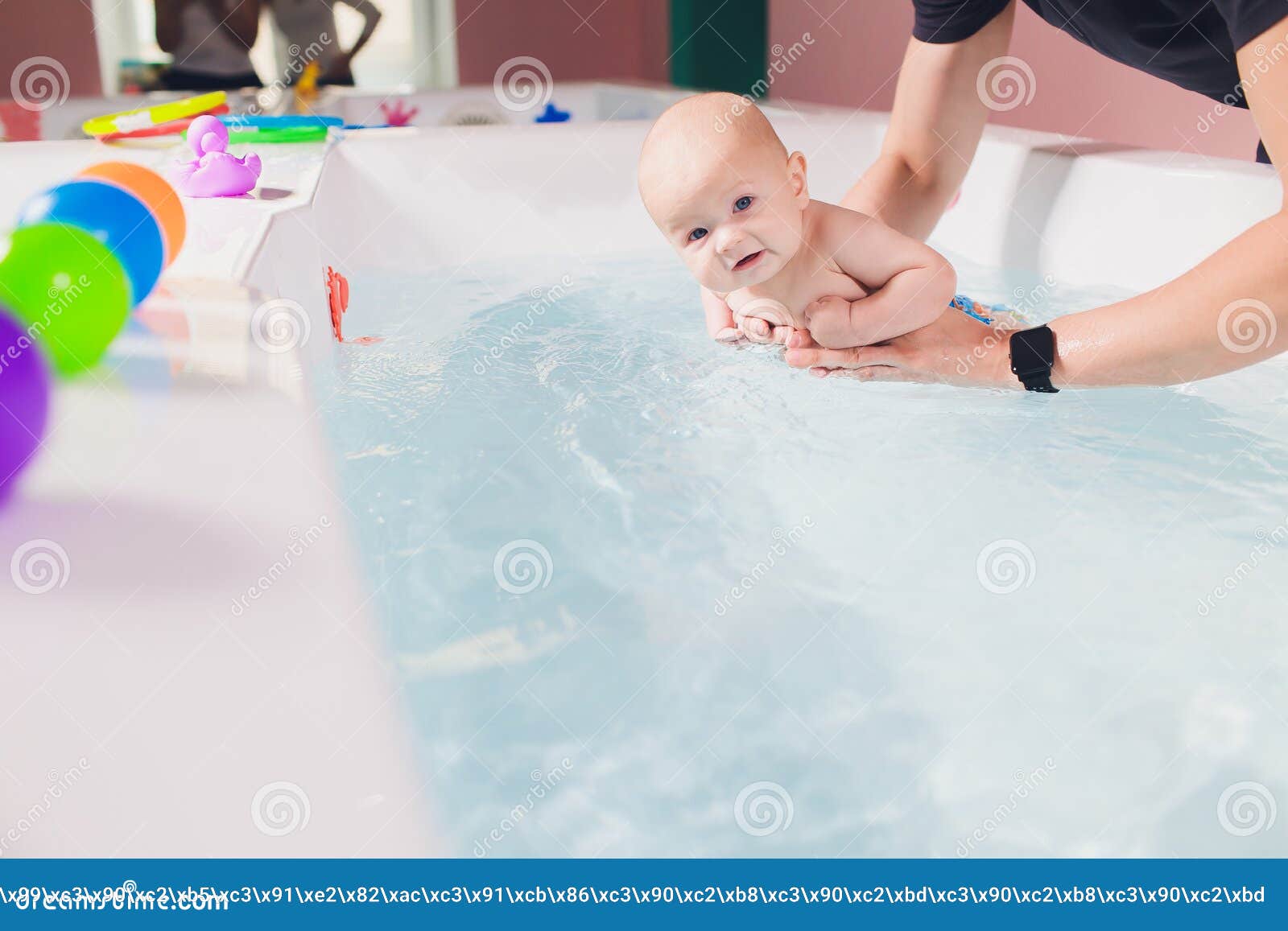 A Father Helps is Infant Boy during Swimming Lessons in the Pool. Stock ...