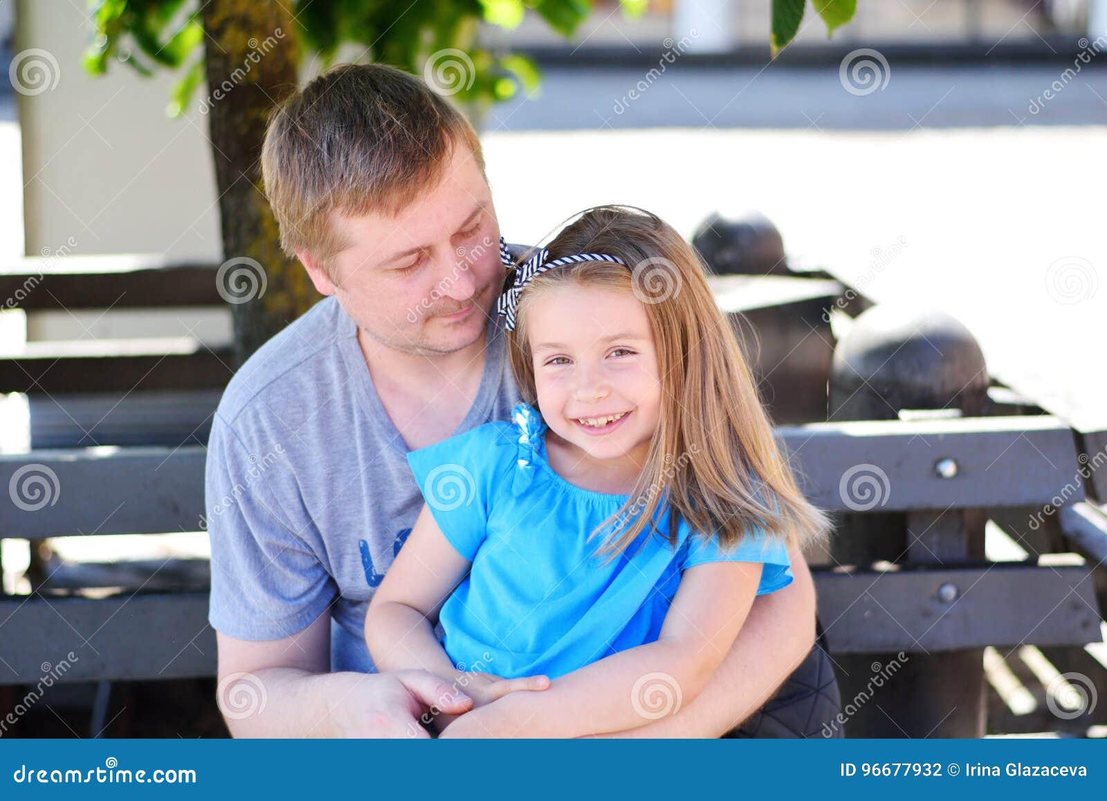 Father Hugging Daughter on the Bench in the Park on Sunny Summer Day ...
