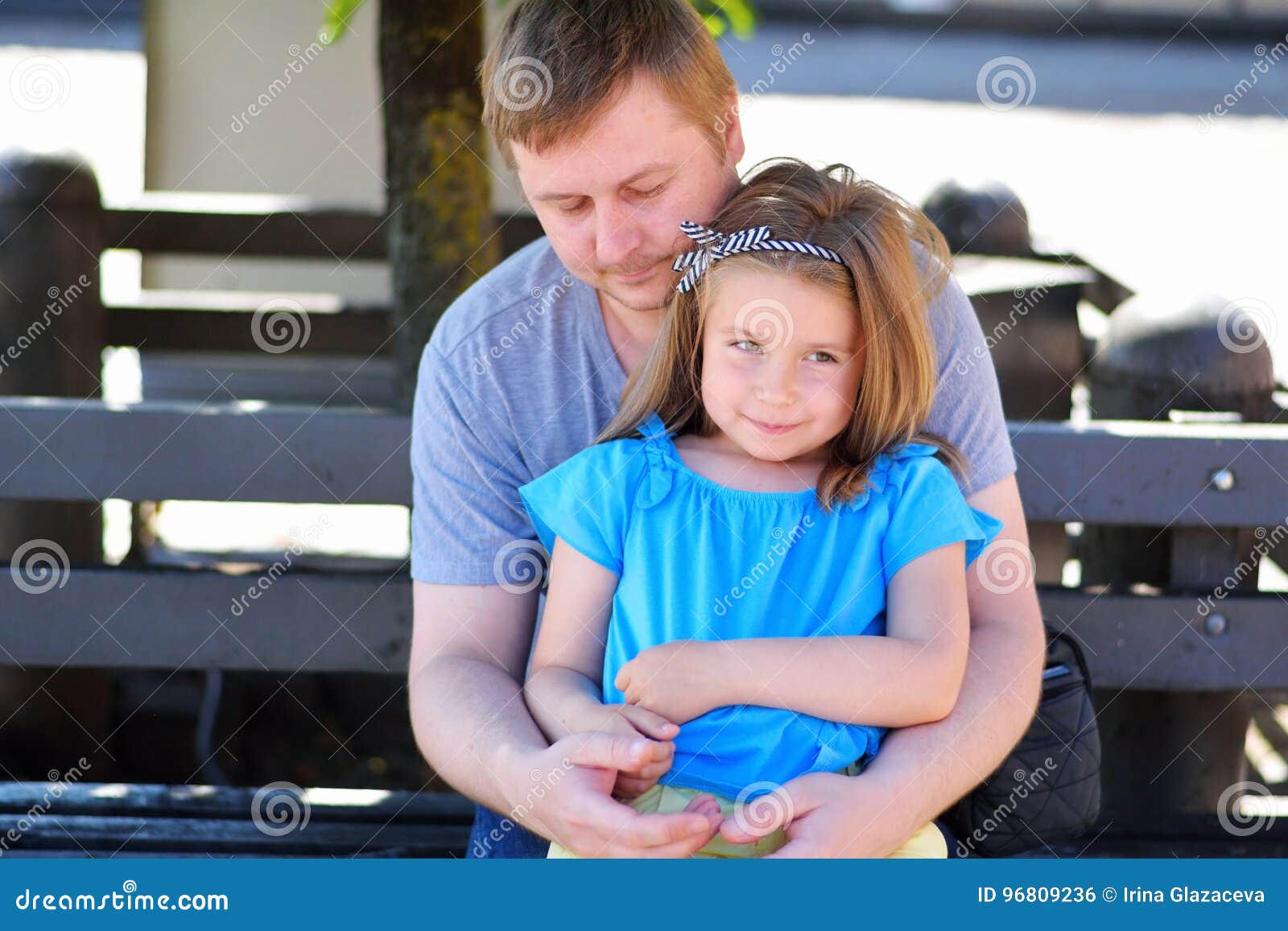 Father Hugging Daughter on the Bench in the Park on Sunny Summer Day ...