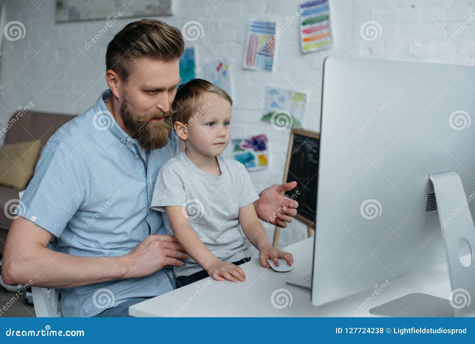 Father and Little Son Looking at Computer Screen while Using Computer ...