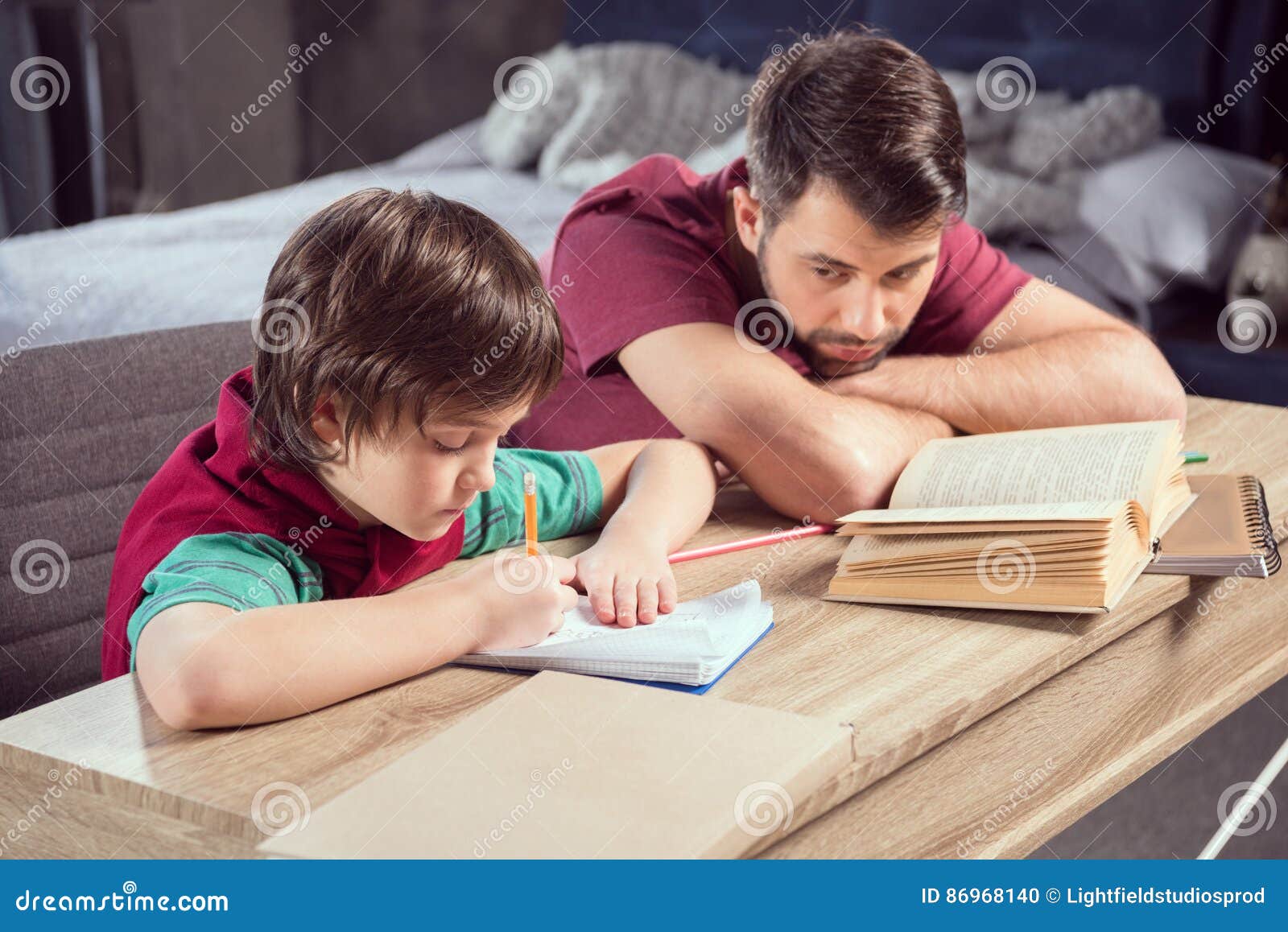 Father Looking at Concentrated Son Doing Homework Stock Photo - Image ...