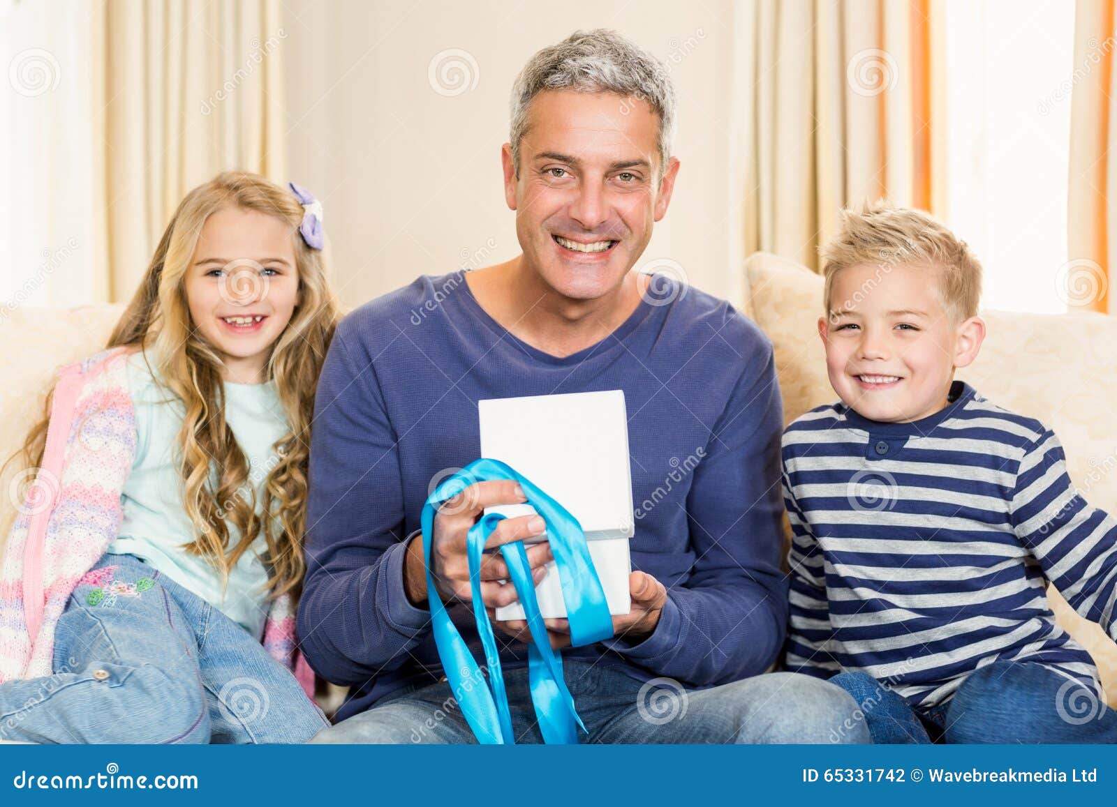 Father Opening Gift Given by Children on Sofa Stock Photo - Image of ...