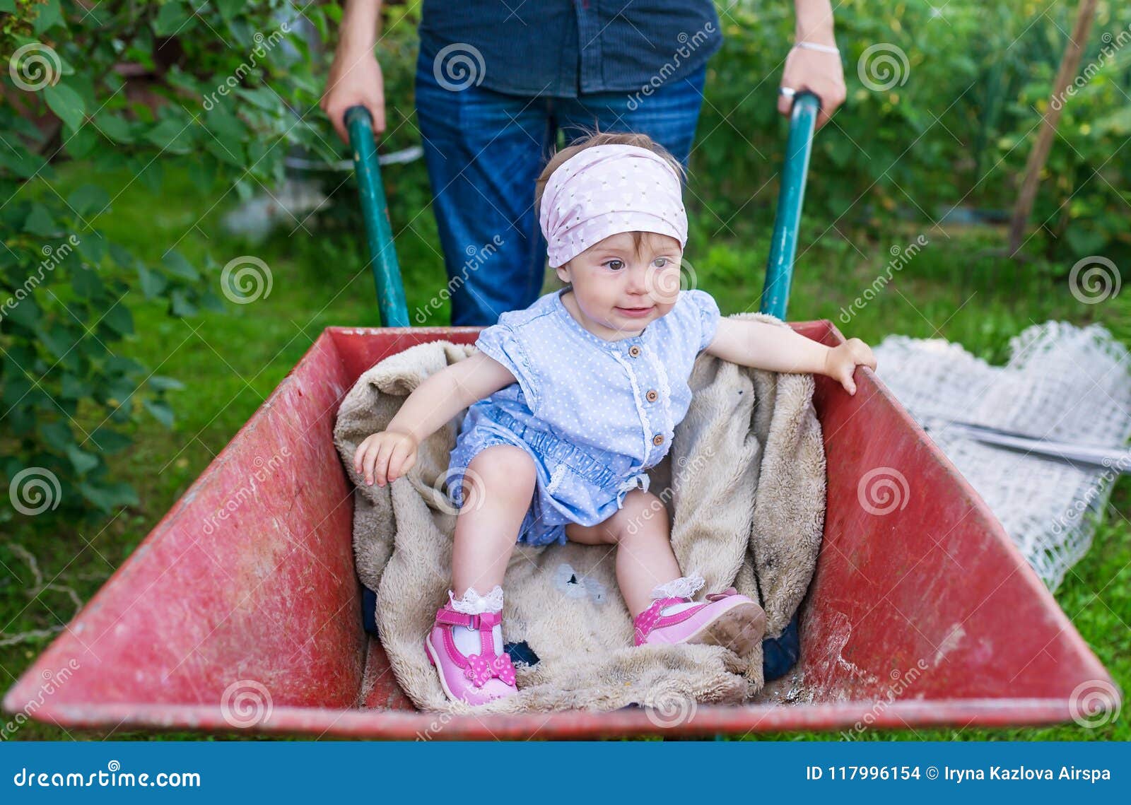 Father Playing with Baby Daughter Using Trolley on Meadow Stock Photo ...