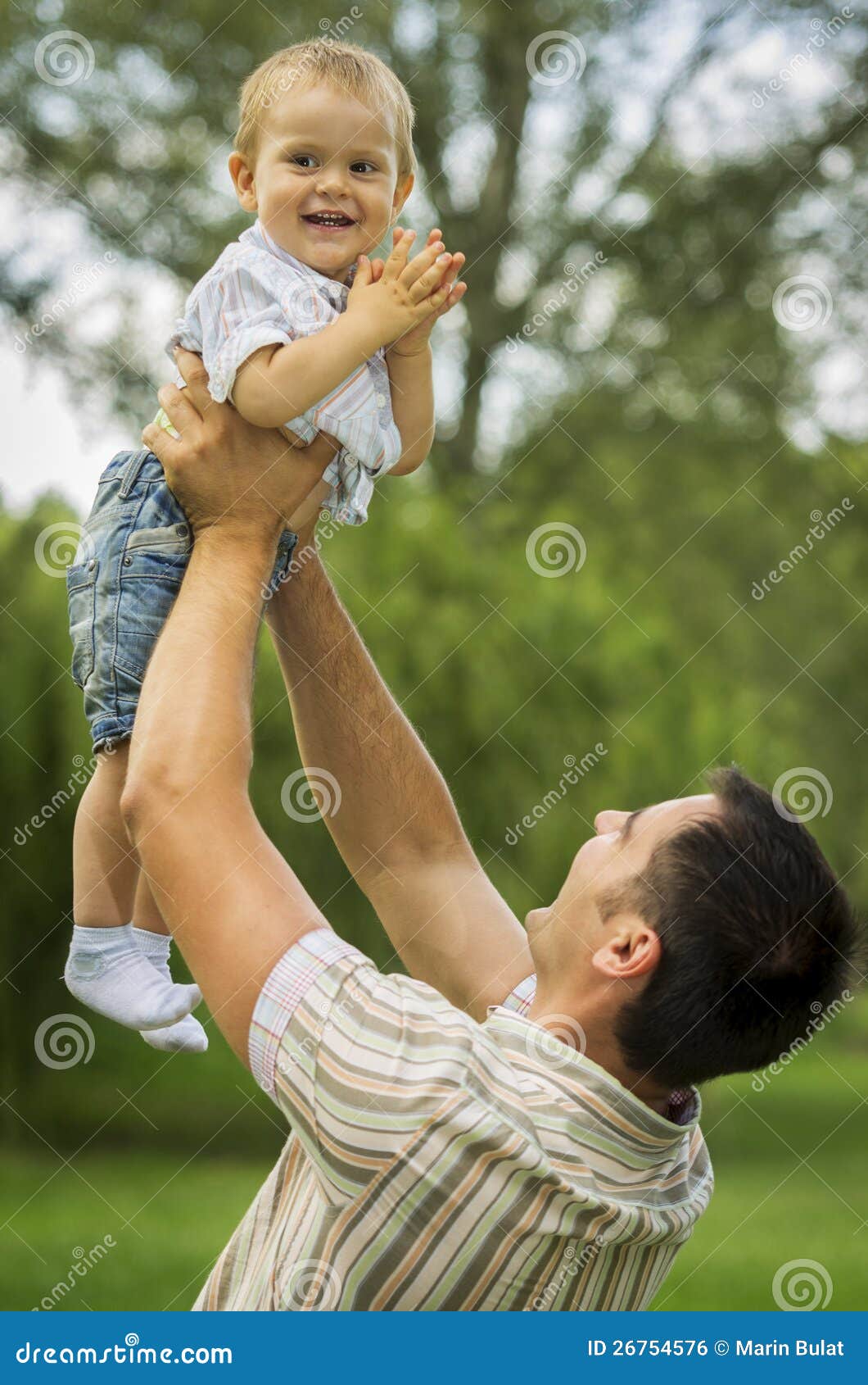 Father raising son in air stock photo. Image of trees - 26754576