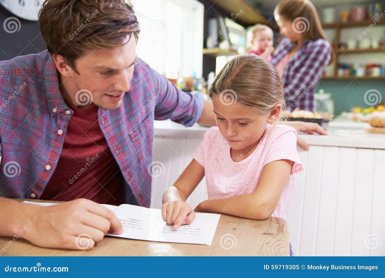 Father Reading Book with Daughter at Kitchen Table Stock Image - Image ...