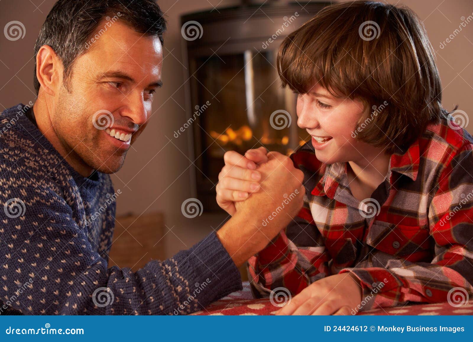 Father And Son Arm Wrestling By Cosy Log Fire Stock Photo ...