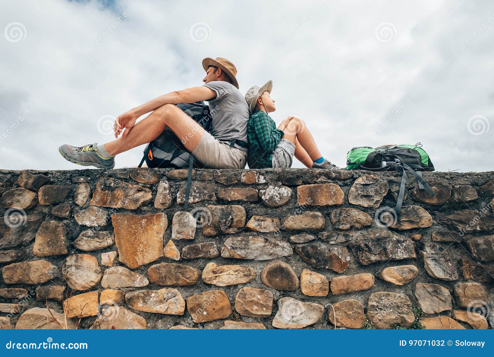 Father and Son Backpacker Traveler Rest Together on Old Stone Wa Stock ...