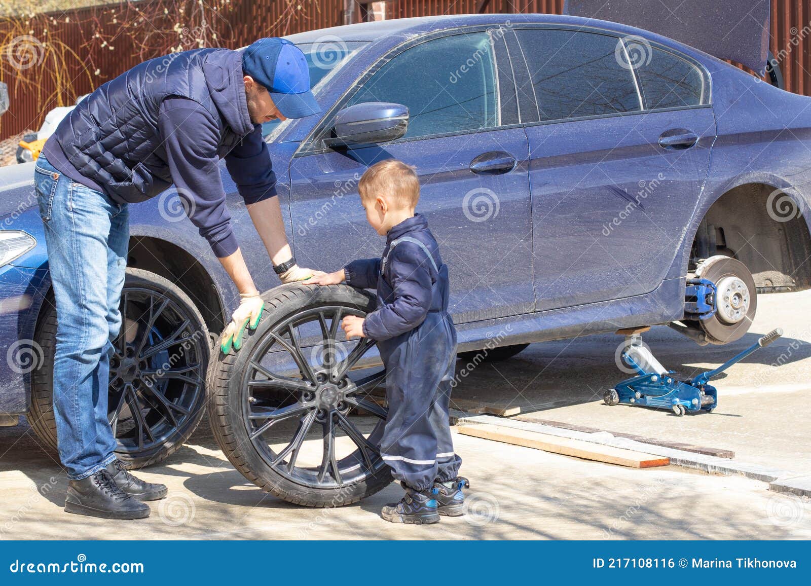 Father and Son are Fixing the Car. the Son Helps the Dad. Happy Father ...