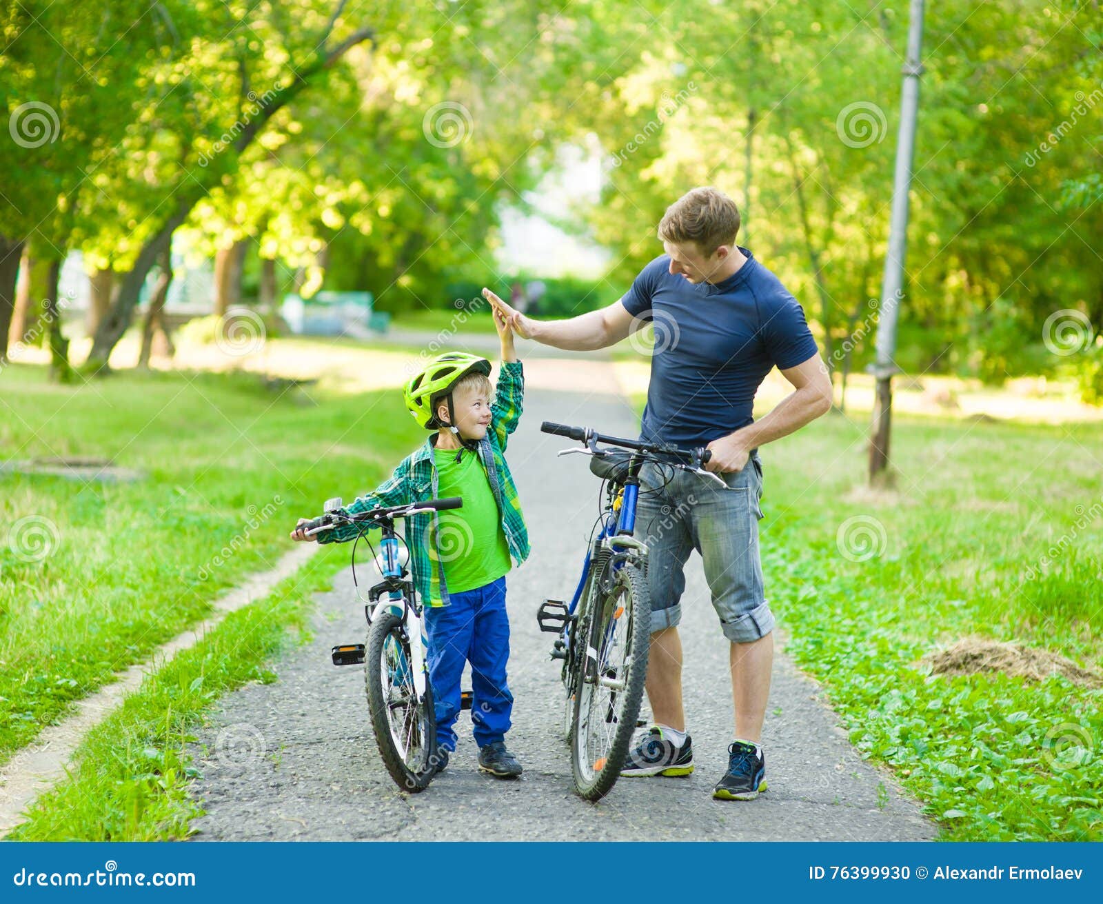 Father and Son Give High Five while Cycling in the Park Stock Photo ...