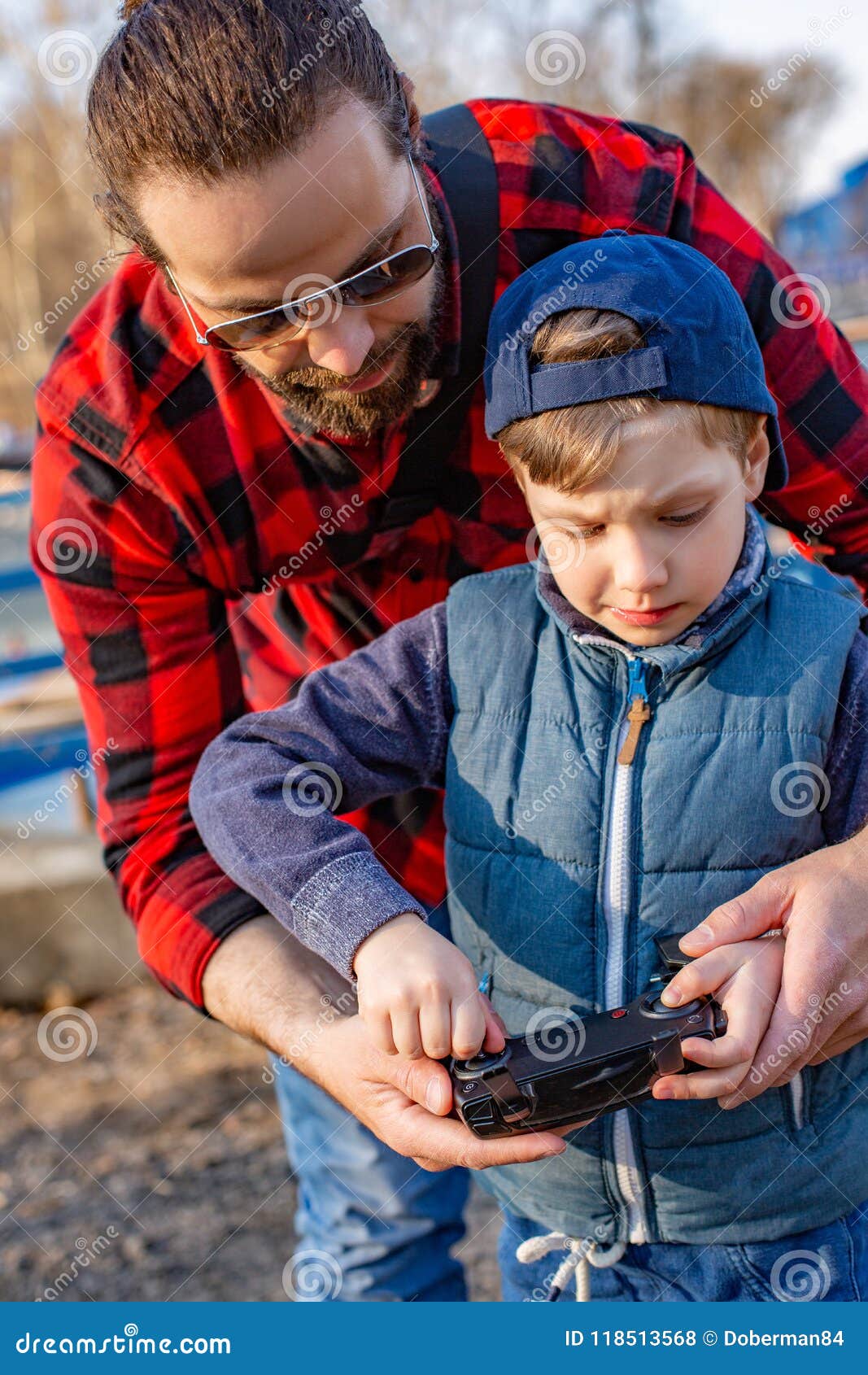 Father and Son Holding Remote Control Joystick and Piloting ...