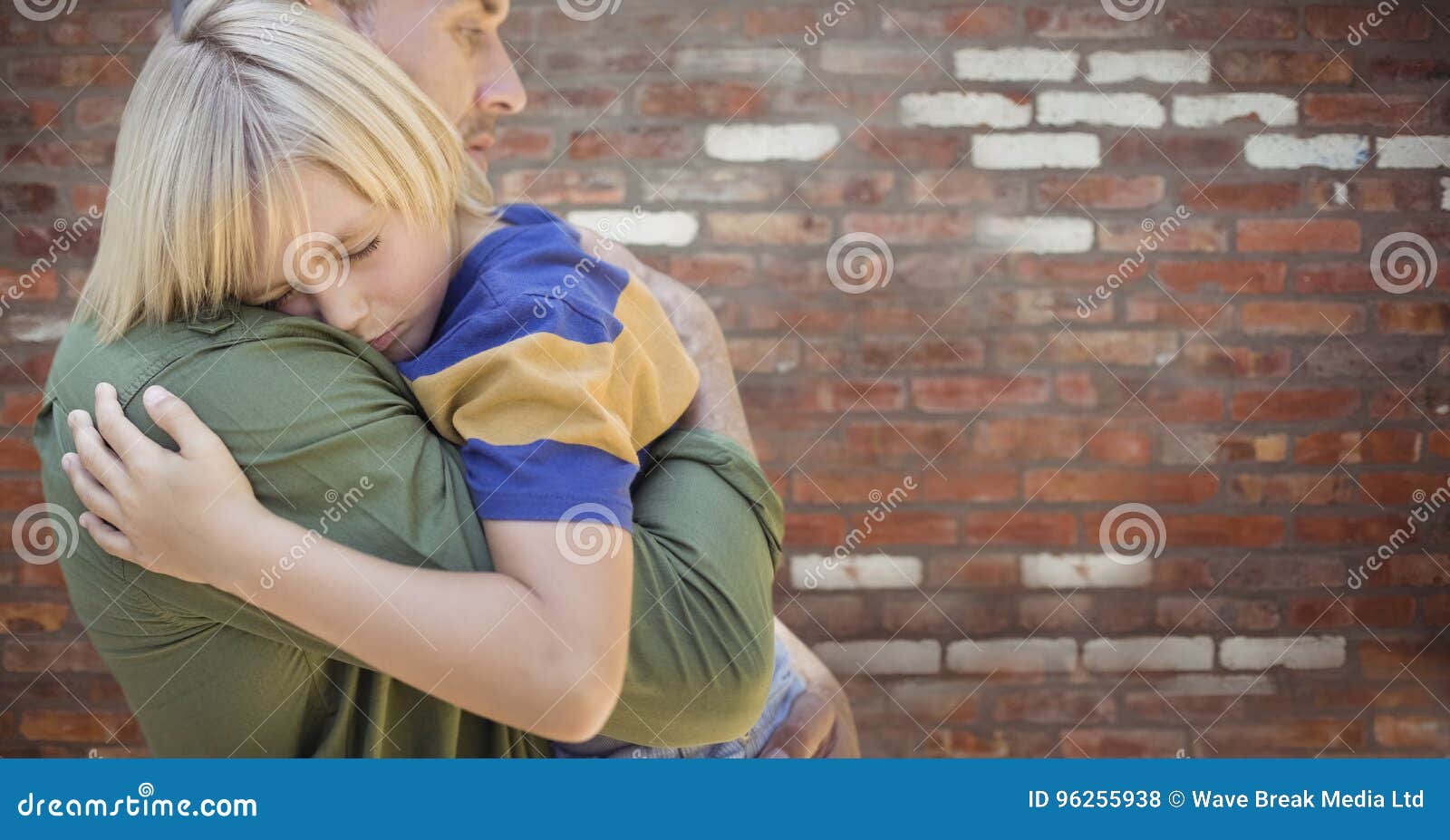 Father and Son Hugging Against Blurry Red Brick Wall Stock Photo ...