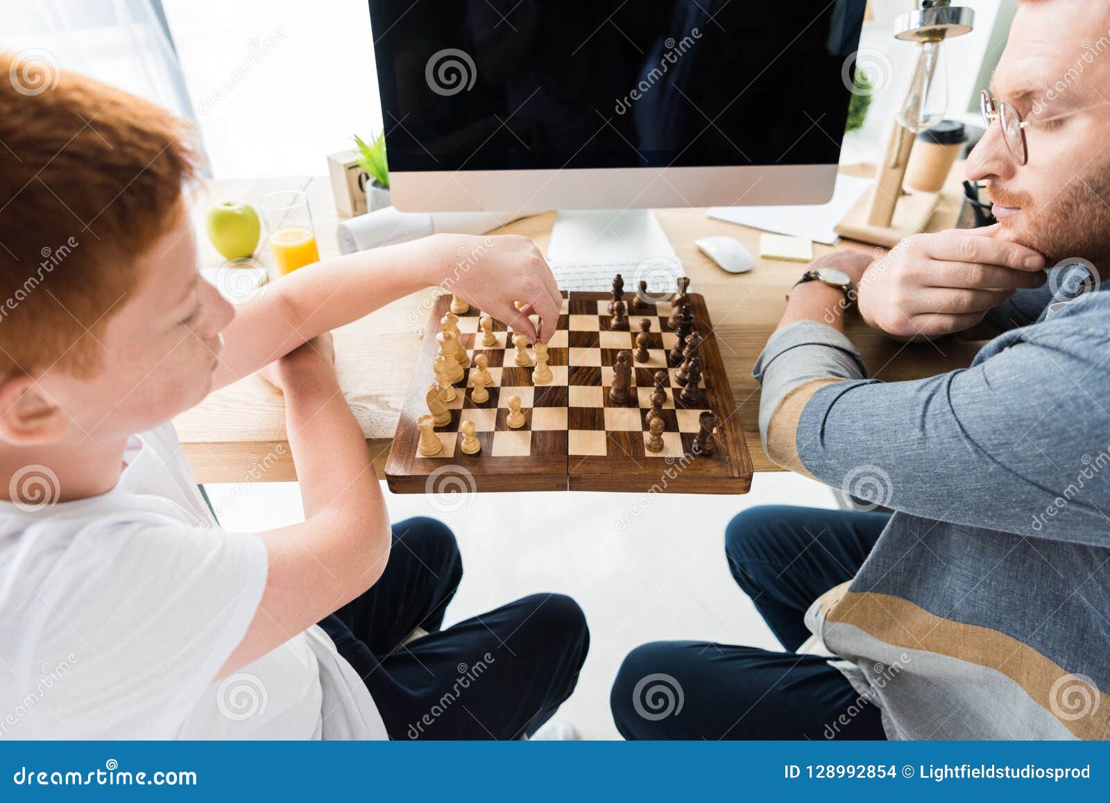 Father and Son Playing Chess at Table with Computer Stock Photo - Image ...