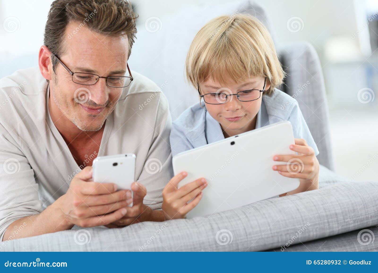 Father and Son Playing with Smartphone and Tablet Stock Photo - Image ...