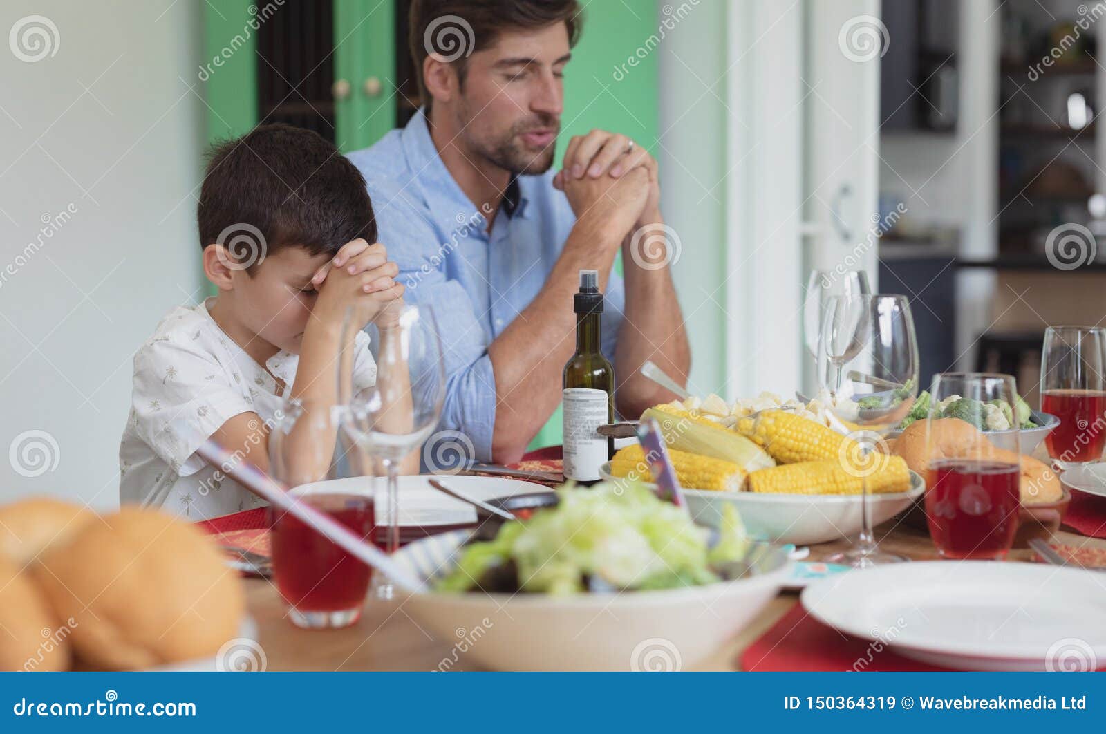 Father and Son Praying before Having Lunch at Dining Table Stock Image ...