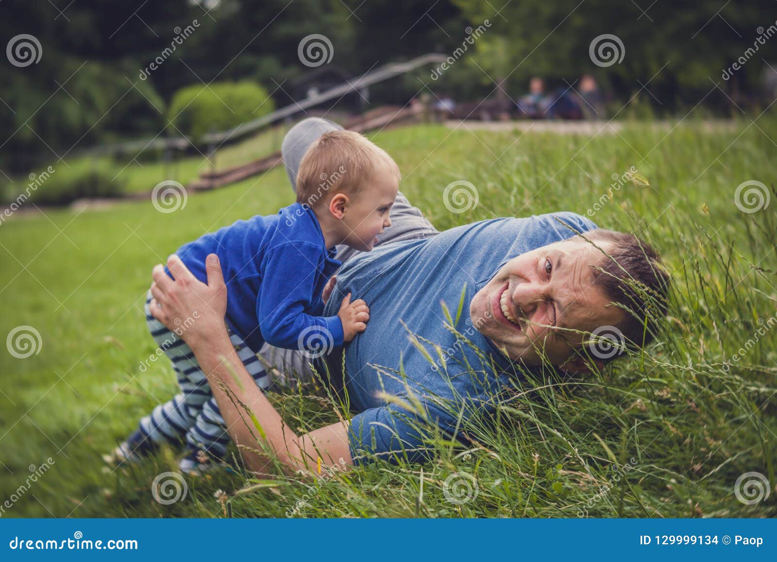 Father and Son Rolling Down on the Grass Stock Photo - Image of ...