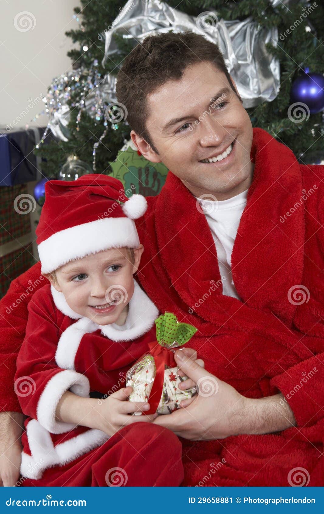 Father and Son in Santa Claus Outfit Holding Present Stock Image ...