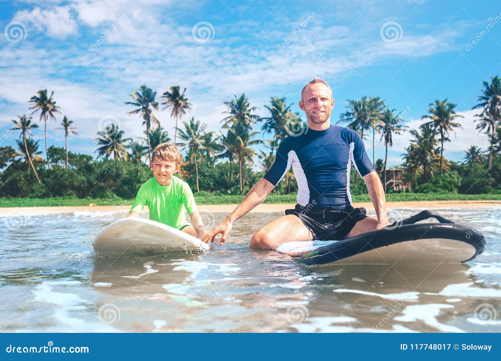 Father and Son Sit on Surfboards. First Surfing Lessons Stock Image ...
