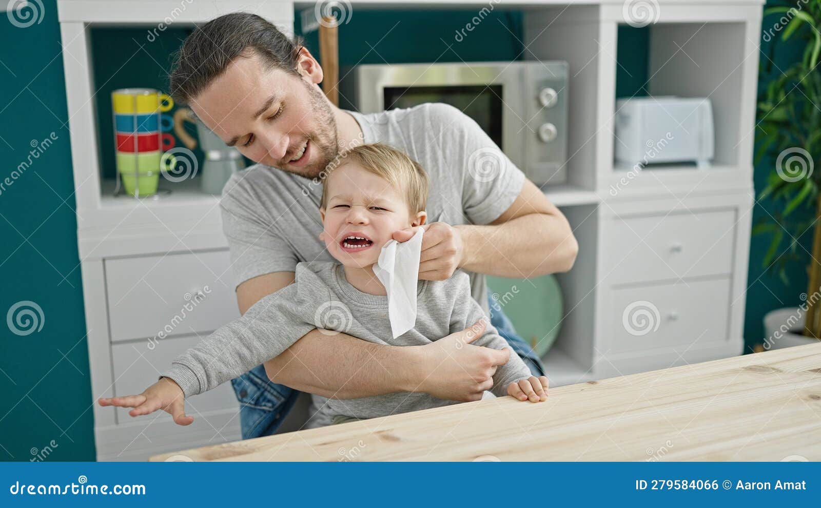 Father and Son Sitting on Table Cleaning Face Crying at Dinning Room ...