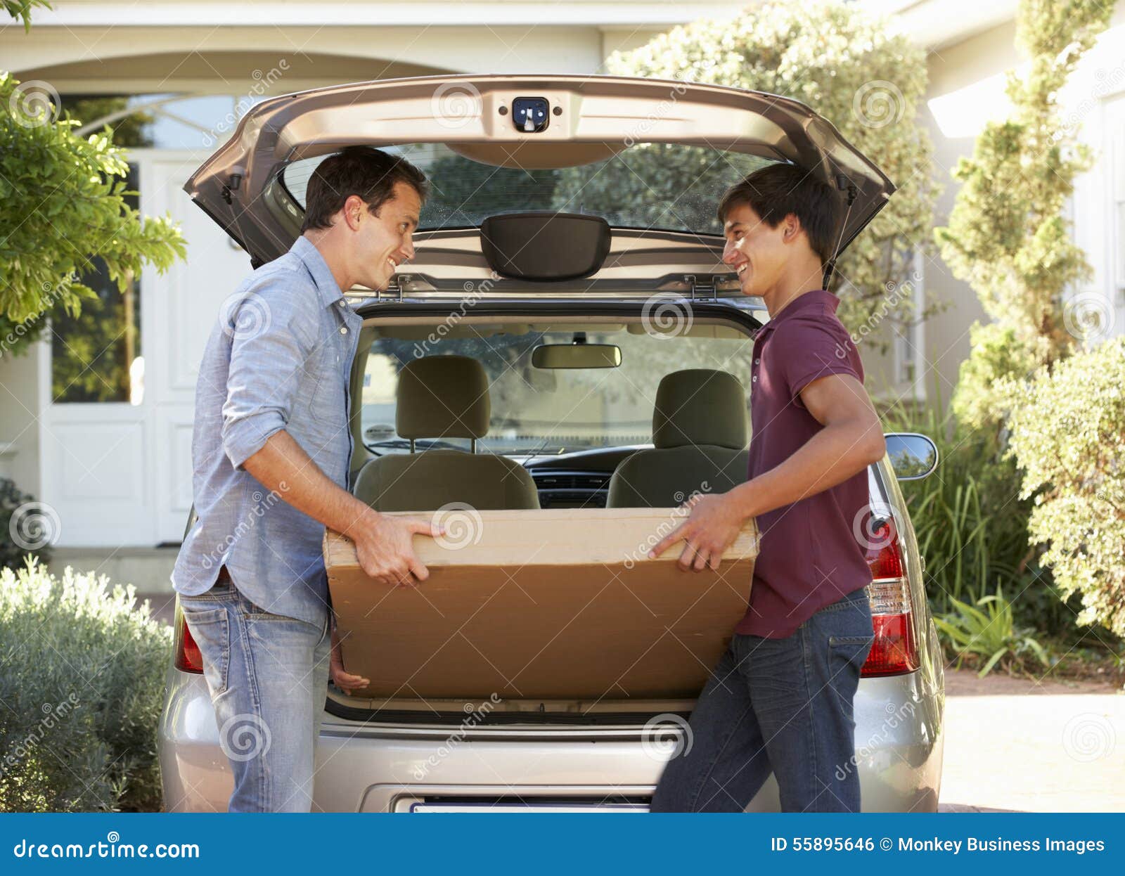 Father and Teenage Son Loading Large Package into Back of Car Stock ...