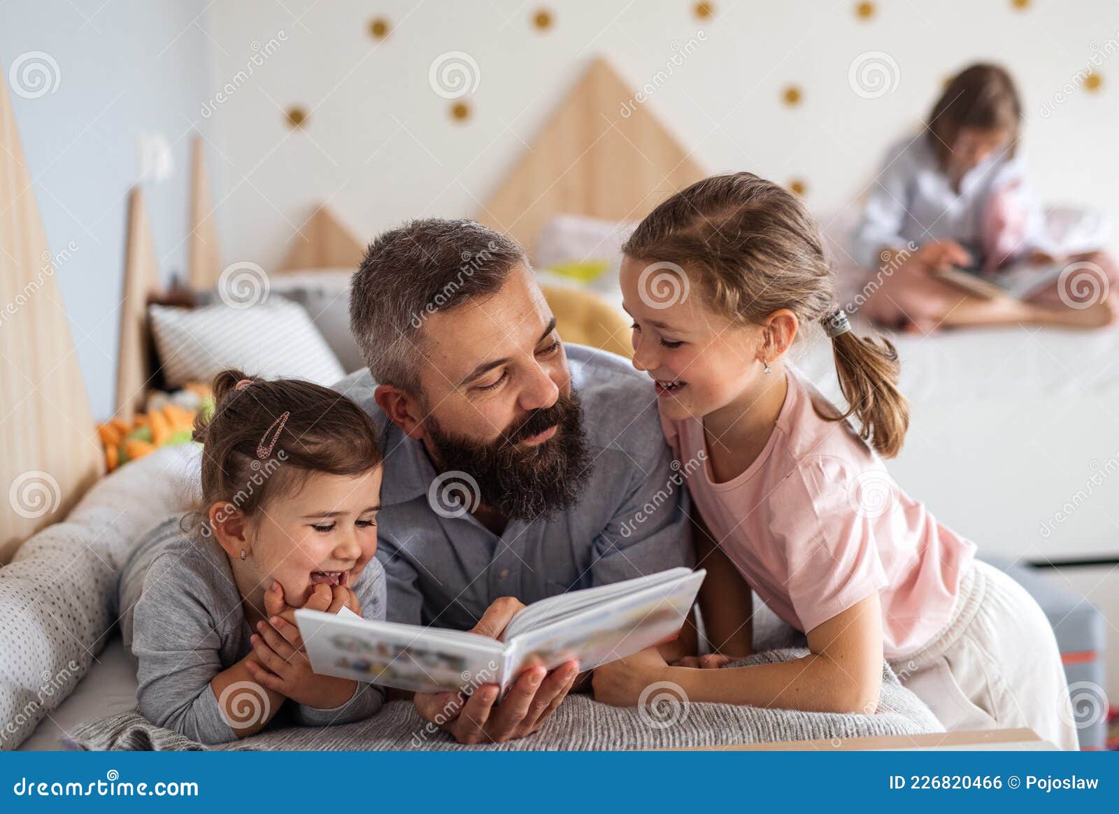 Father with Three Daughters Indoors at Home, Reading a Book. Stock ...