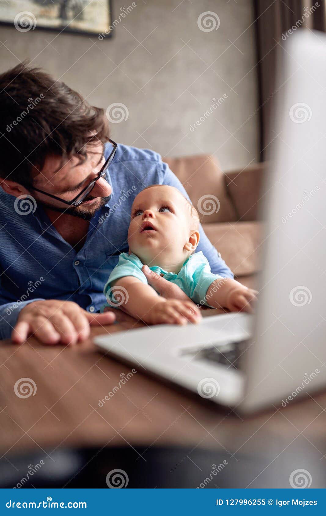 Father Using a Laptop Computer for Work at Home while Looking Af Stock ...