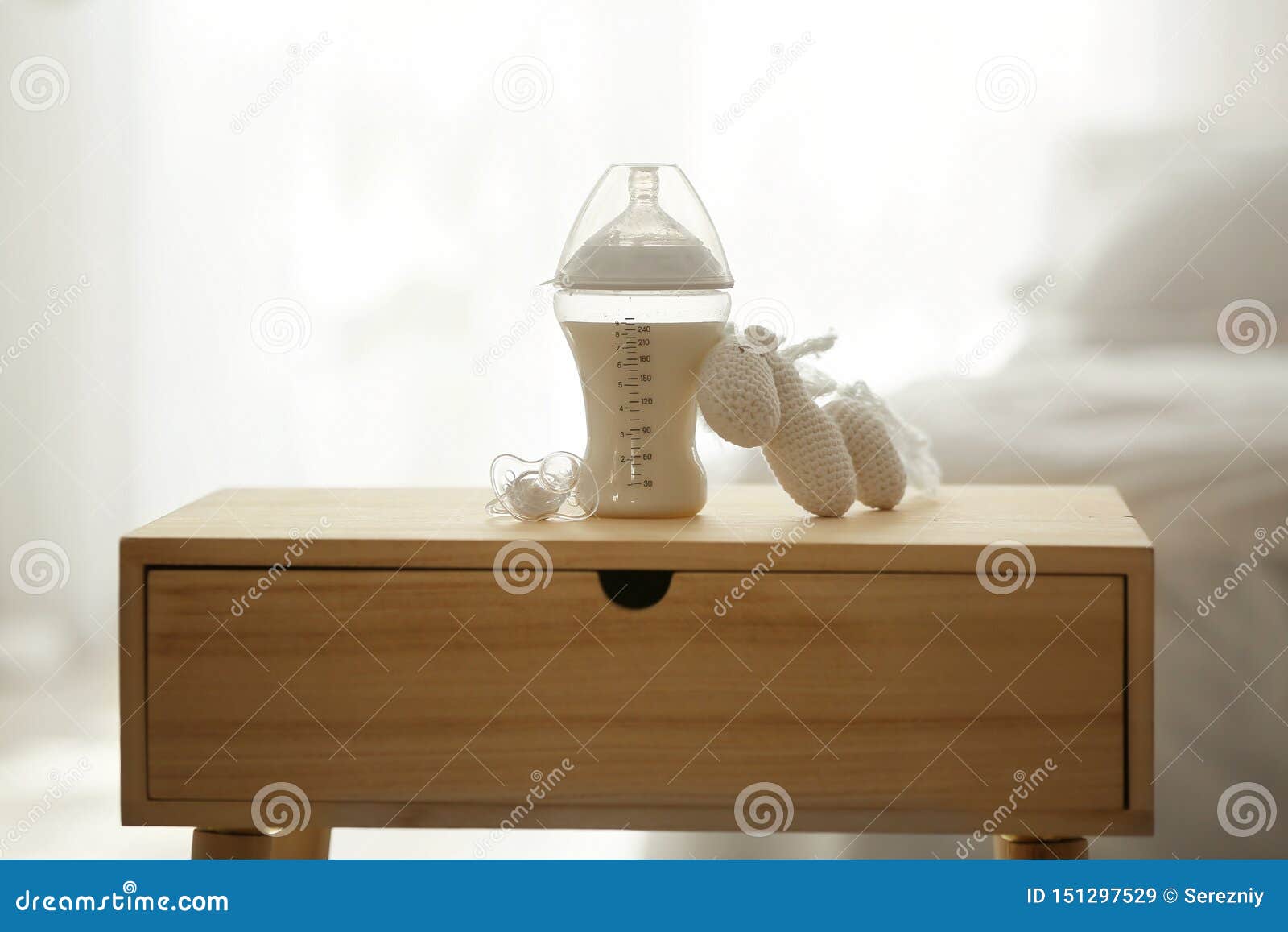 Feeding Bottle with Milk, Soother and Toy on Table in Light Room Stock ...