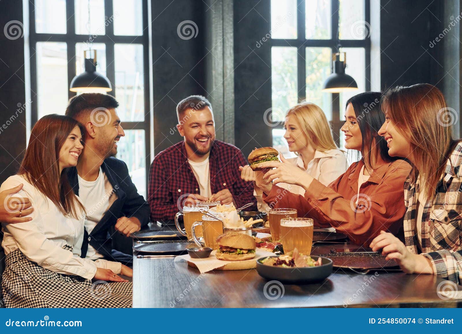 Feeling Joy. Group of Young Friends Sitting Together in Bar with Beer ...