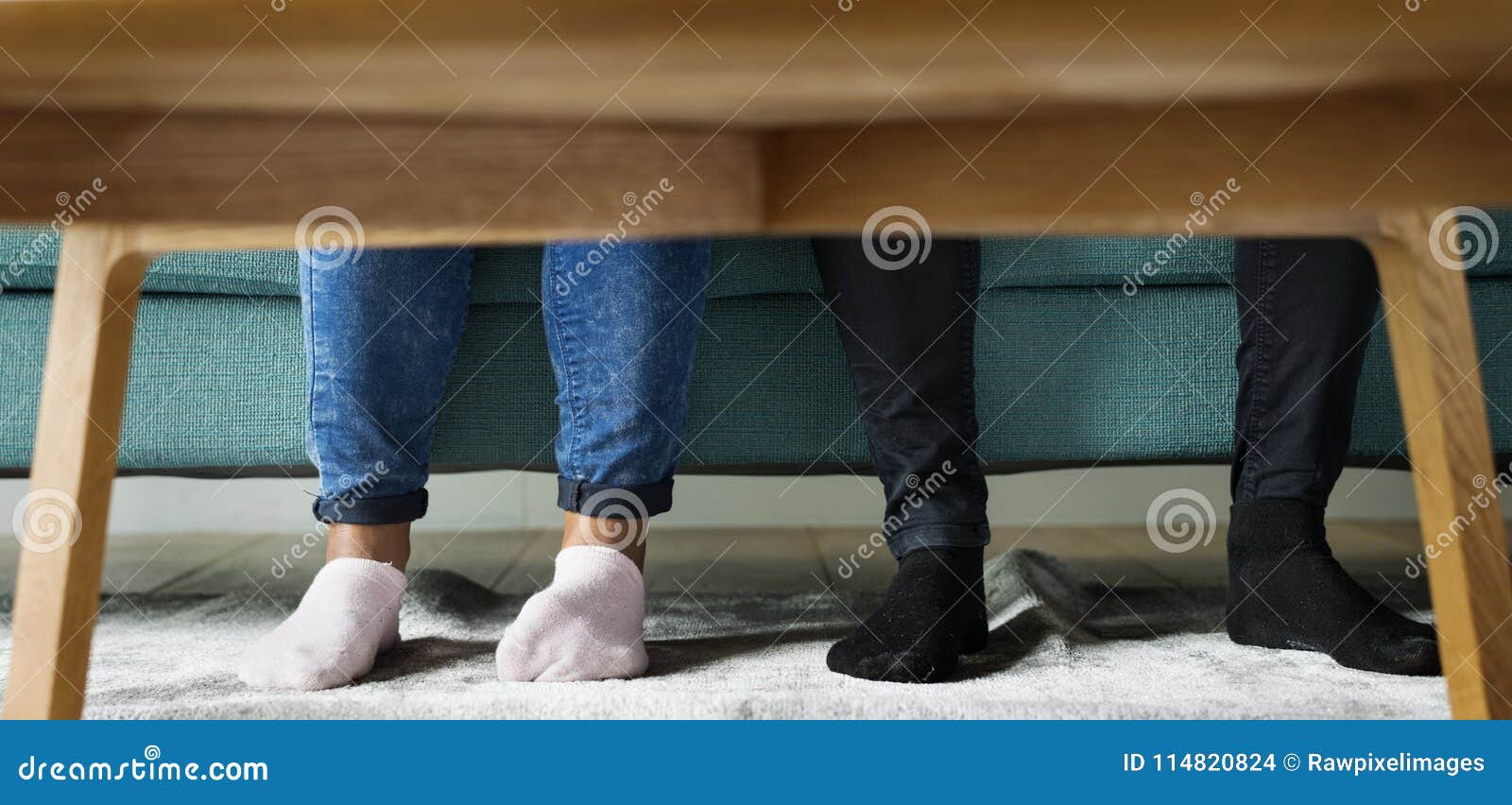 Feet Sticking Out Under a Sofa Table Stock Photo - Image of sitting ...