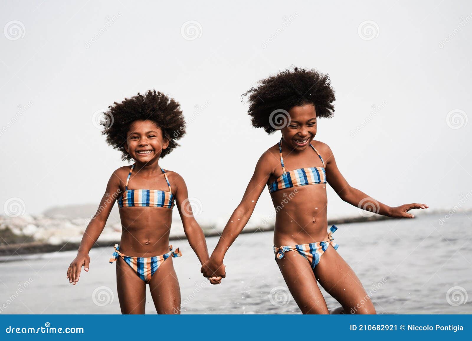 Feliz African Sister Twins Running on the Beach Together Principal ... Feliz African Sister Twins Running on the Beach Together Principal ...