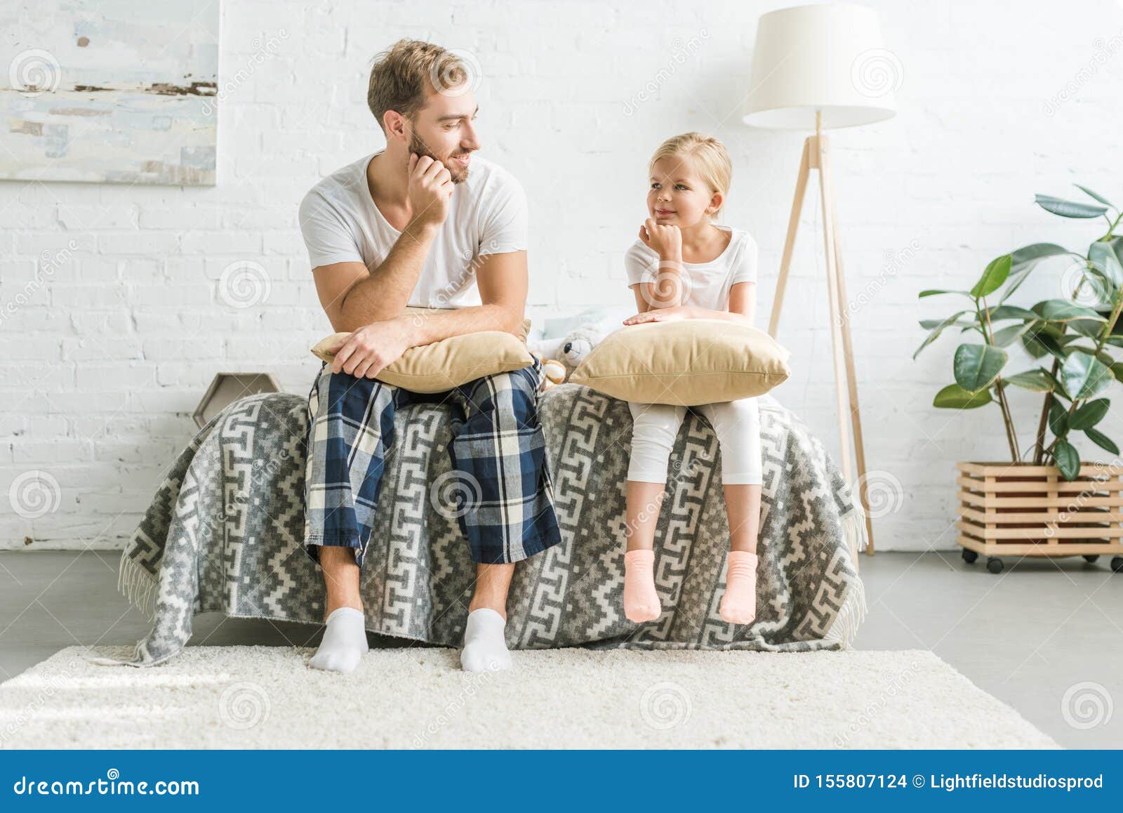 Feliz Pai E Filha Bonitinha Sentada Com Travesseiros Na Cama E Foto De