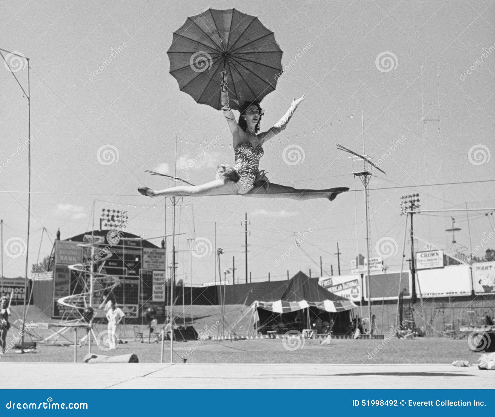 A Female Acrobat Lies On A Gray Bedspread In A Curved Pose And Uses A ...