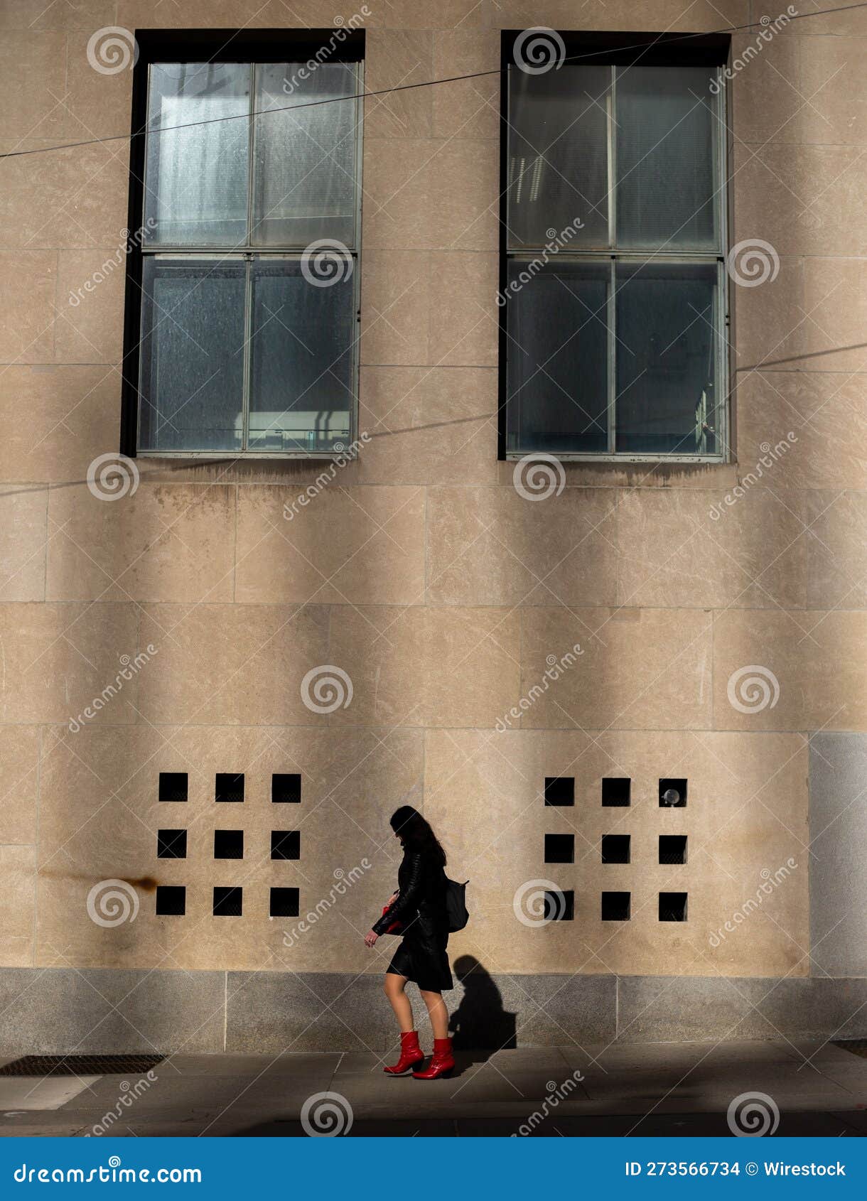 Female Adult Walking in Front of Two Large Windows in a Modern Building ...