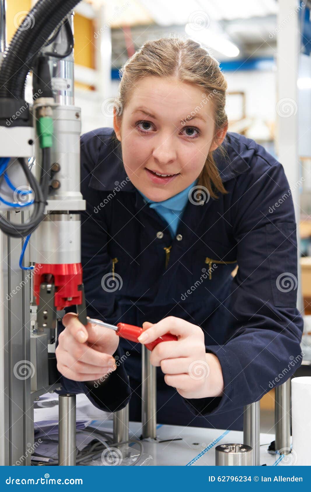 Female Apprentice Engineer Working on Machine in Factory Stock Photo ...