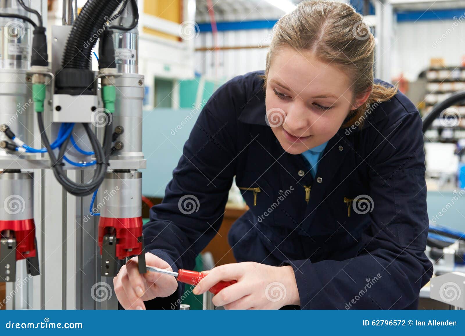 Female Apprentice Engineer Working on Machine in Factory Stock Photo ...
