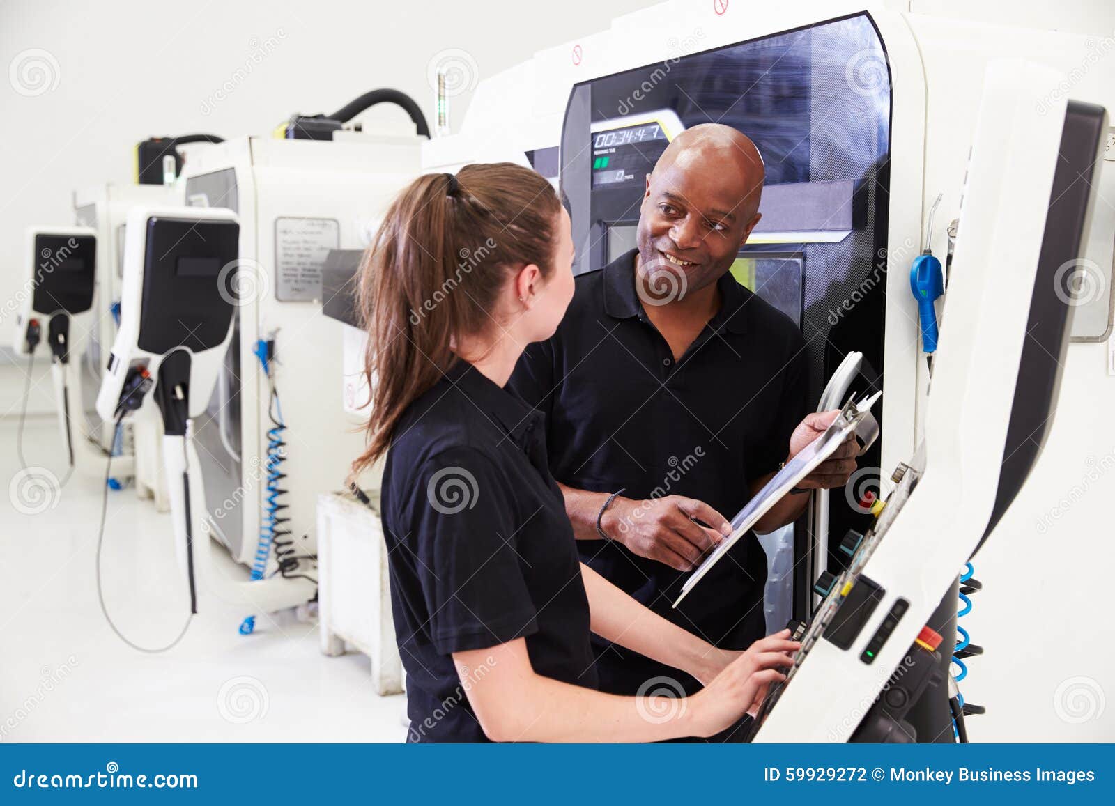 Female Apprentice Working with Engineer on CNC Machinery Stock Photo ...