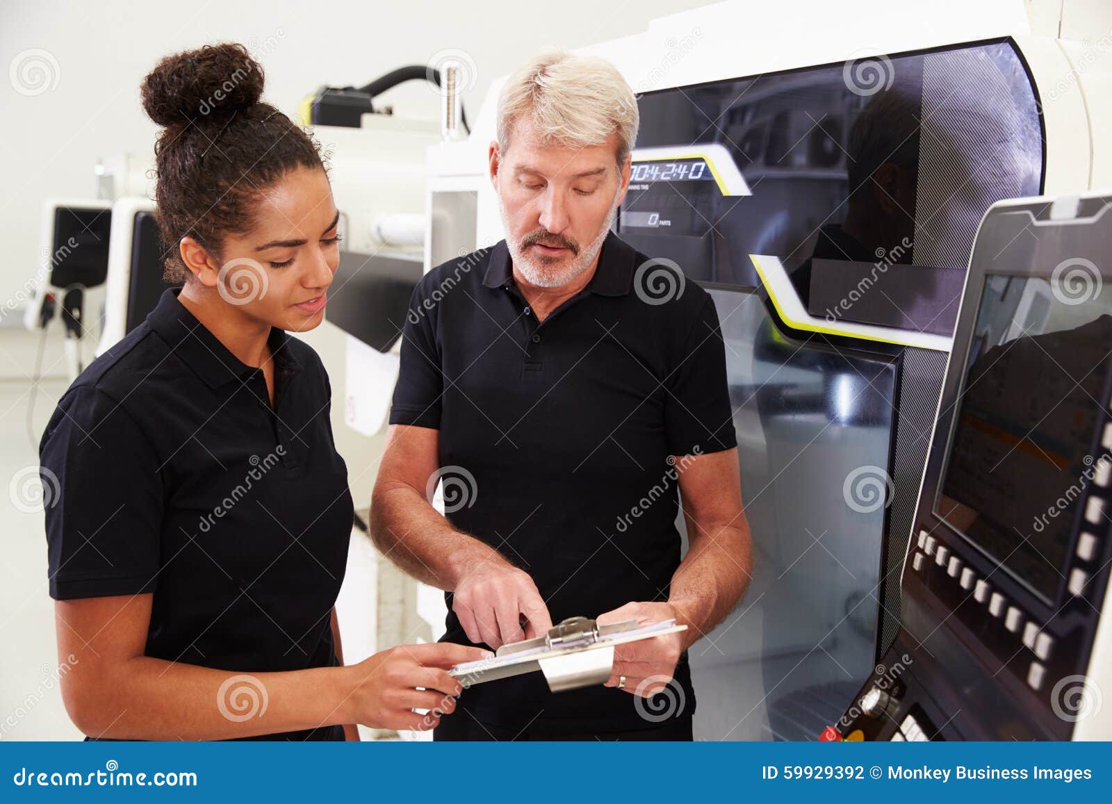 Female Apprentice Working with Engineer on CNC Machinery Stock Photo ...
